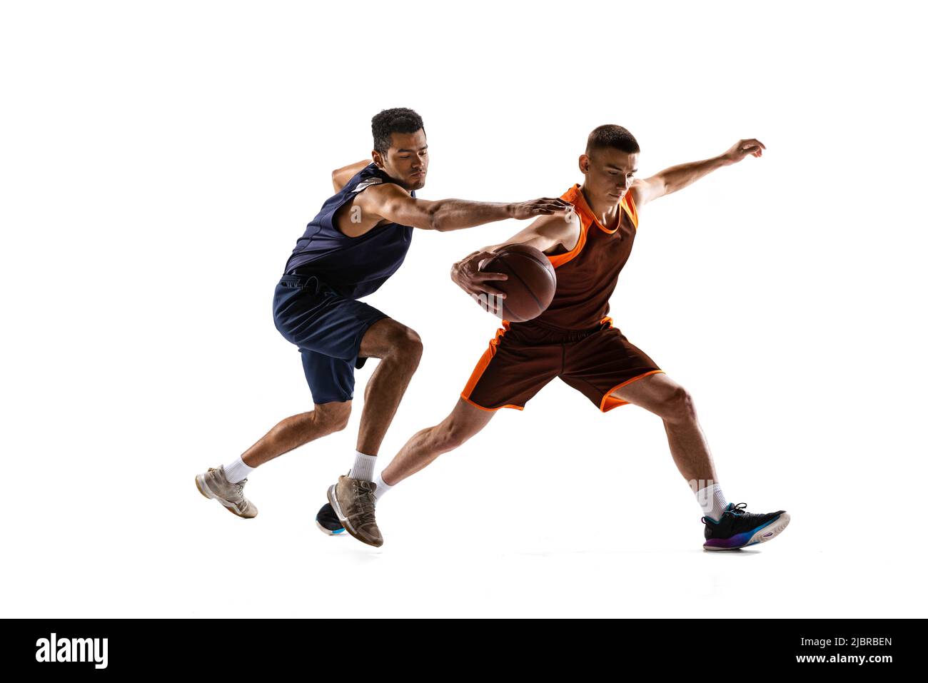 Portrait of two sportive men, basketball players in uniform playing ...