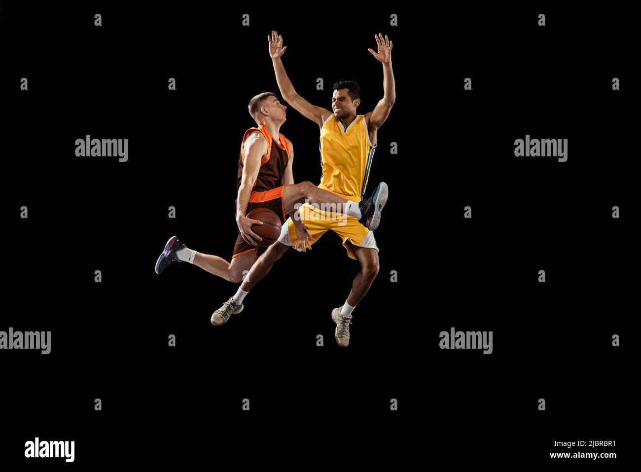 Dynamic portrait of two young men, professional basketball players in a ...