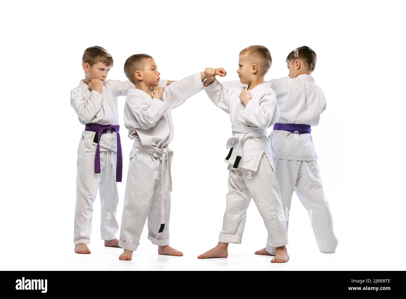 Little beginner karate fighters in white doboks and colorful belts ...