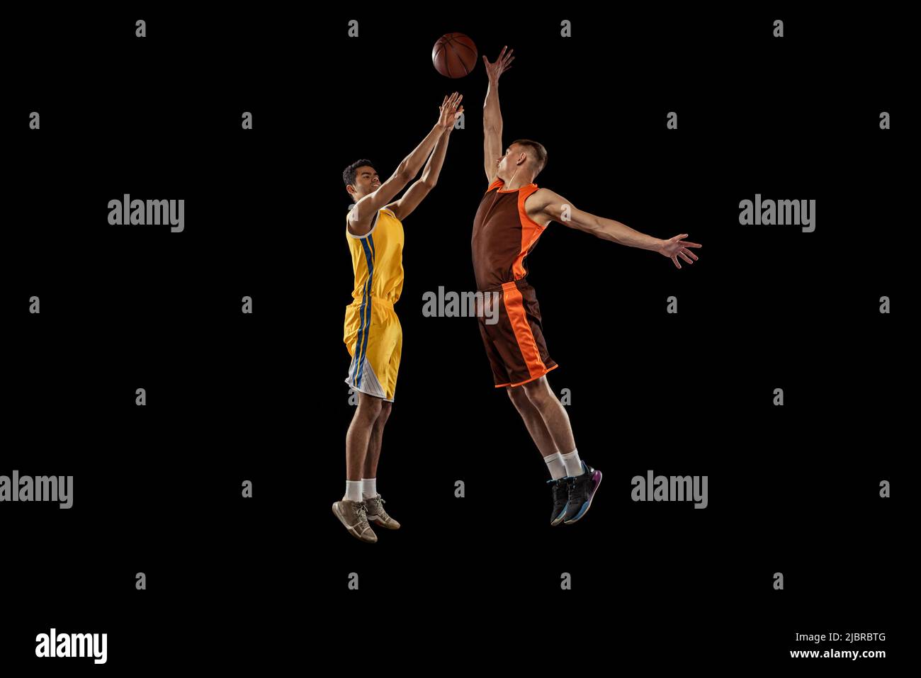 Dynamic portrait of two young men, professional basketball players in a ...