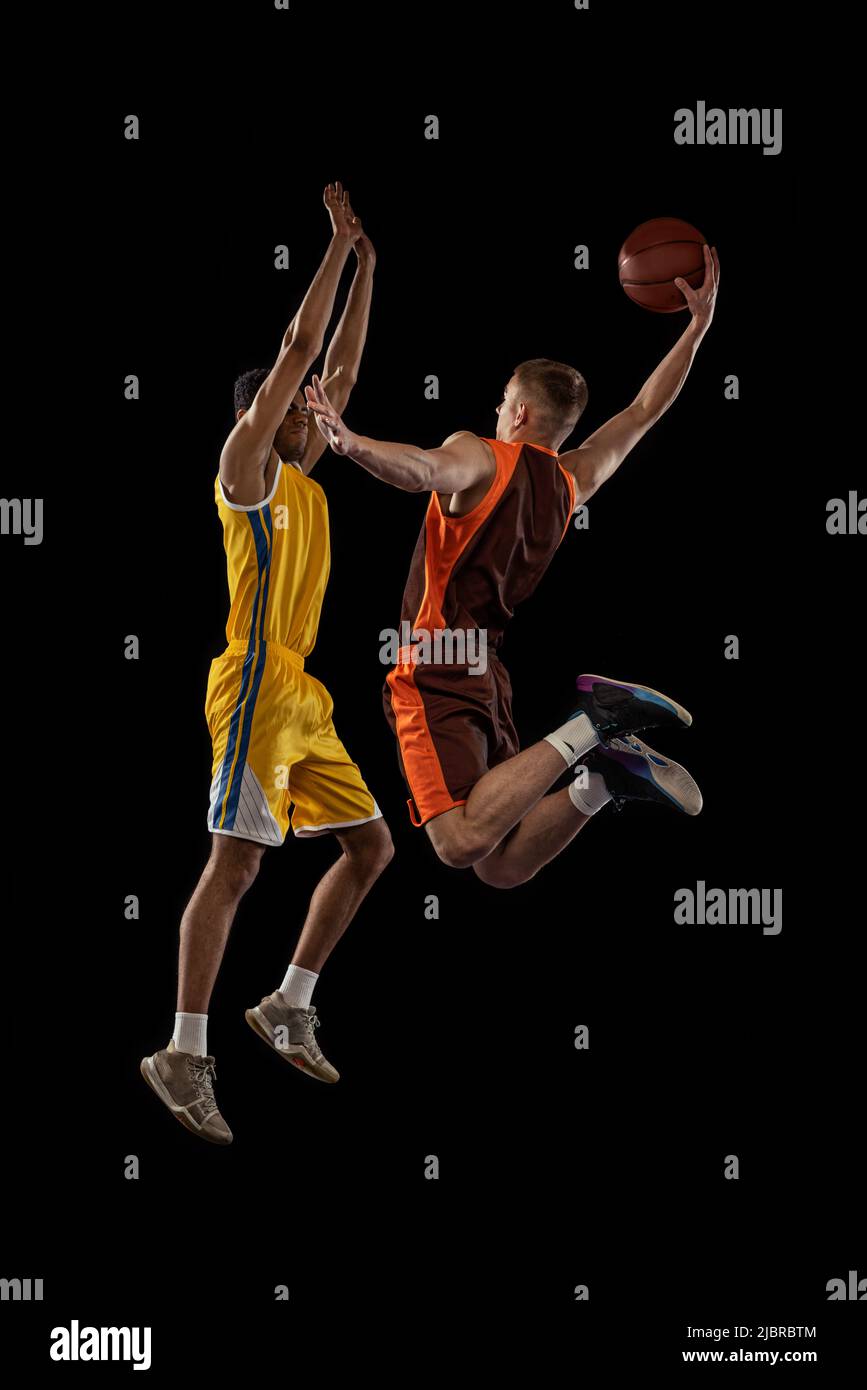 Portrait of two young men, professional basketball players in a jump ...