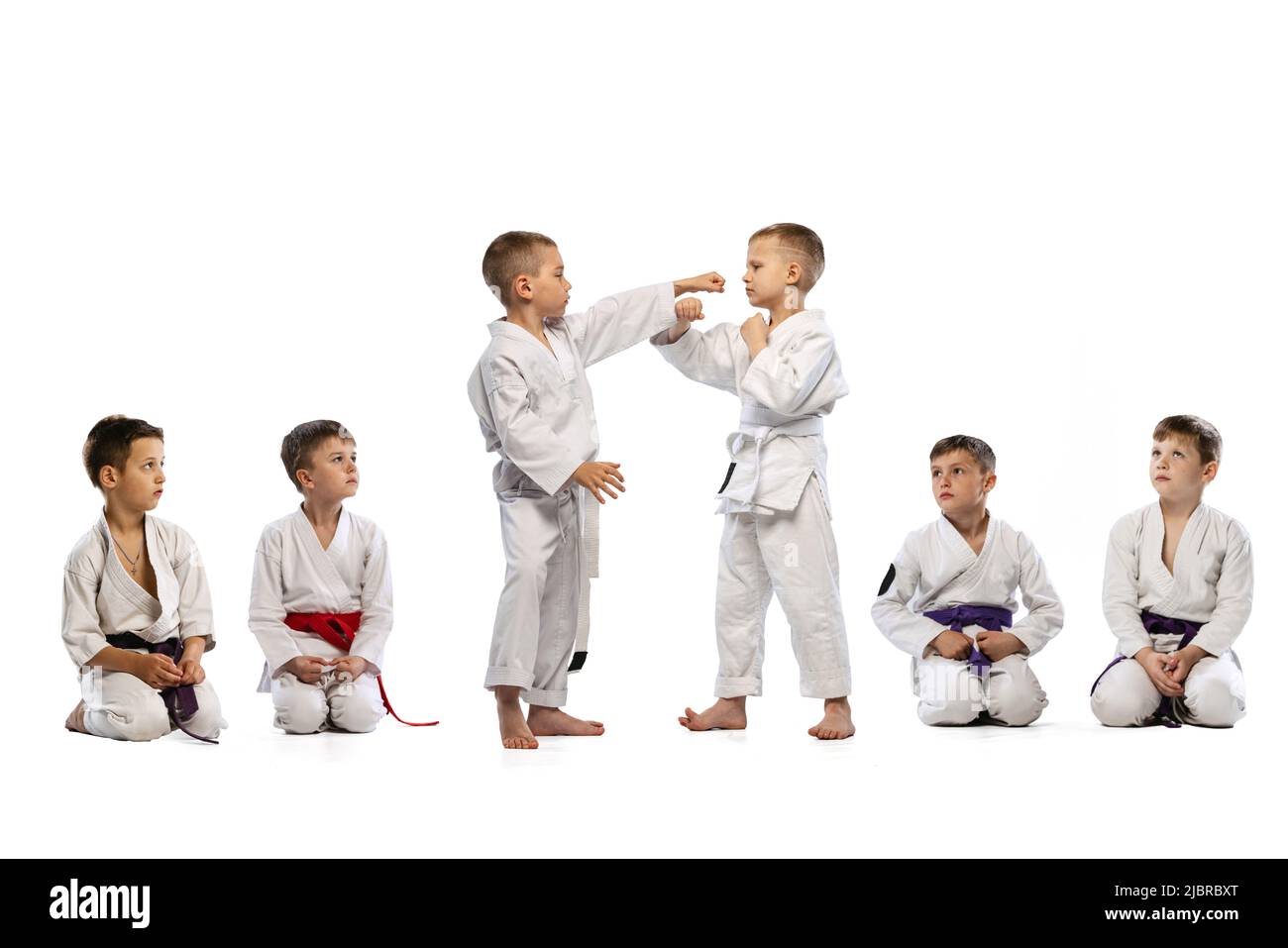 Little beginner karate fighters in white doboks and colorful belts ...