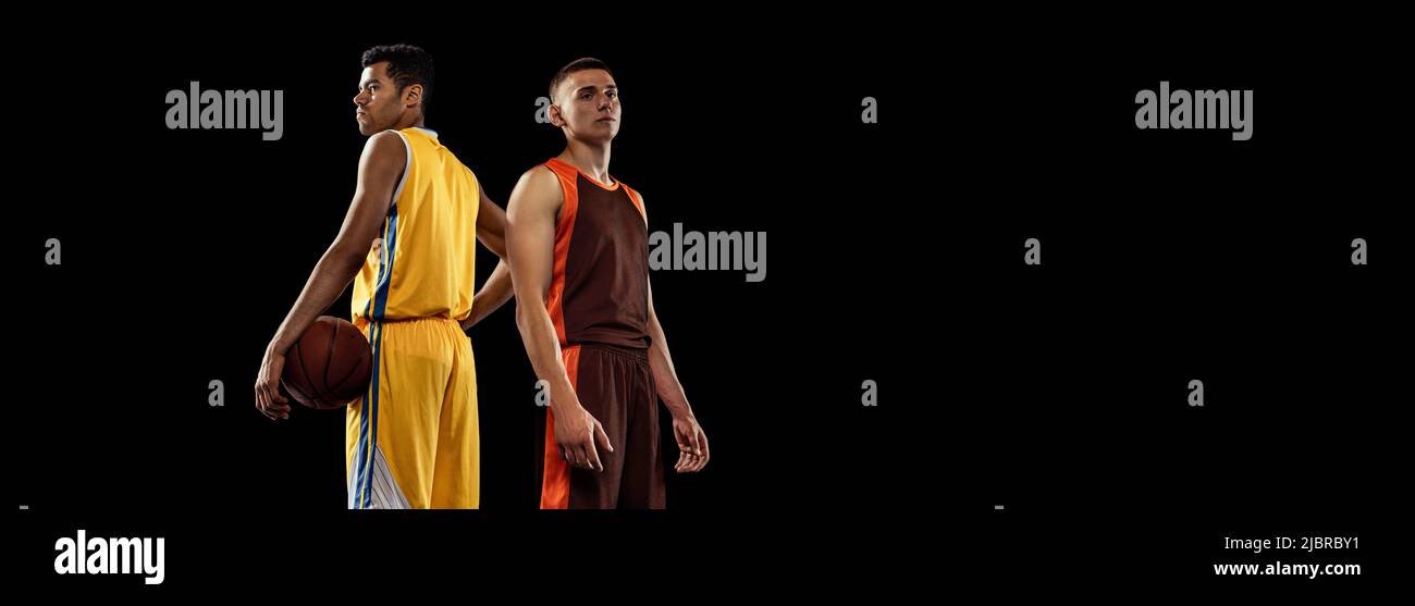 Portrait of two young men, professional basketball players standing ...