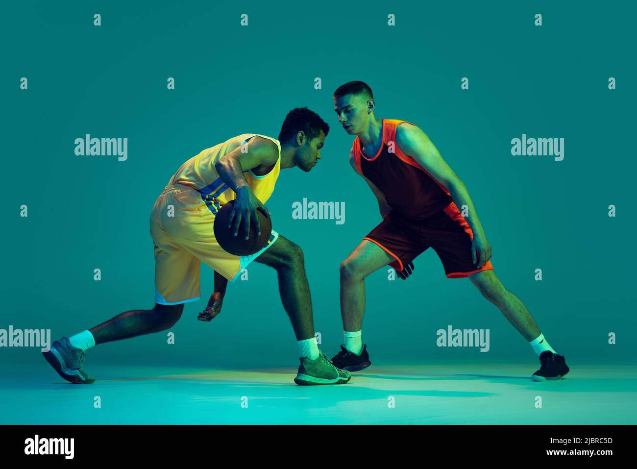 Portrait of two men, professional basketball players in motion ...
