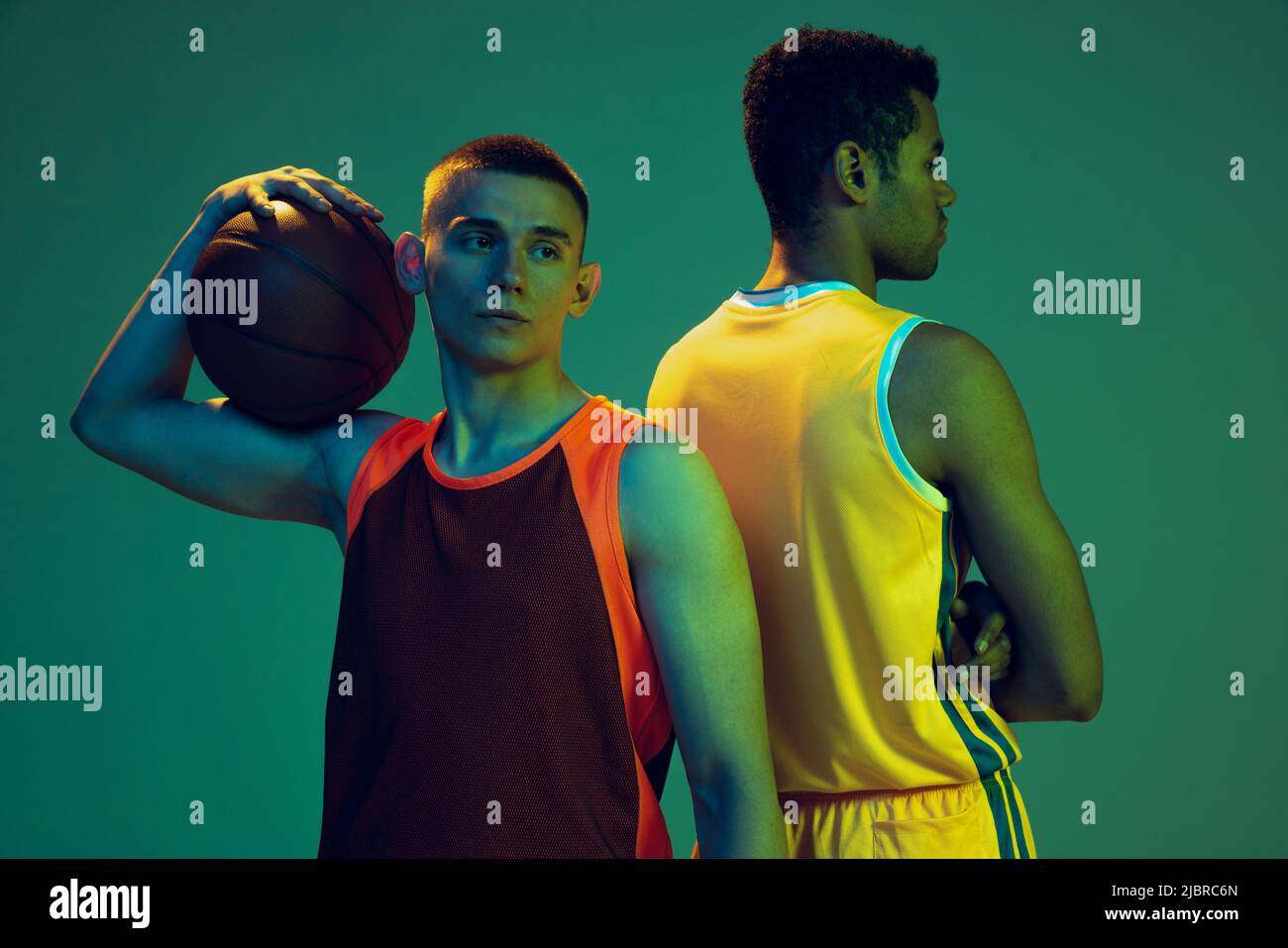 Portrait of two young men, professional basketball players standing ...