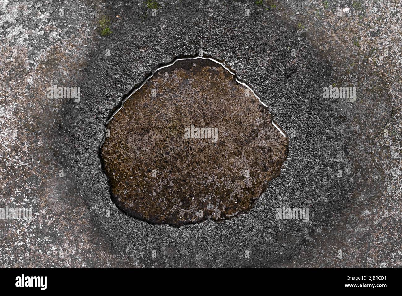 Round water puddle on concrete pavement in Bali, Indonesia Stock Photo ...