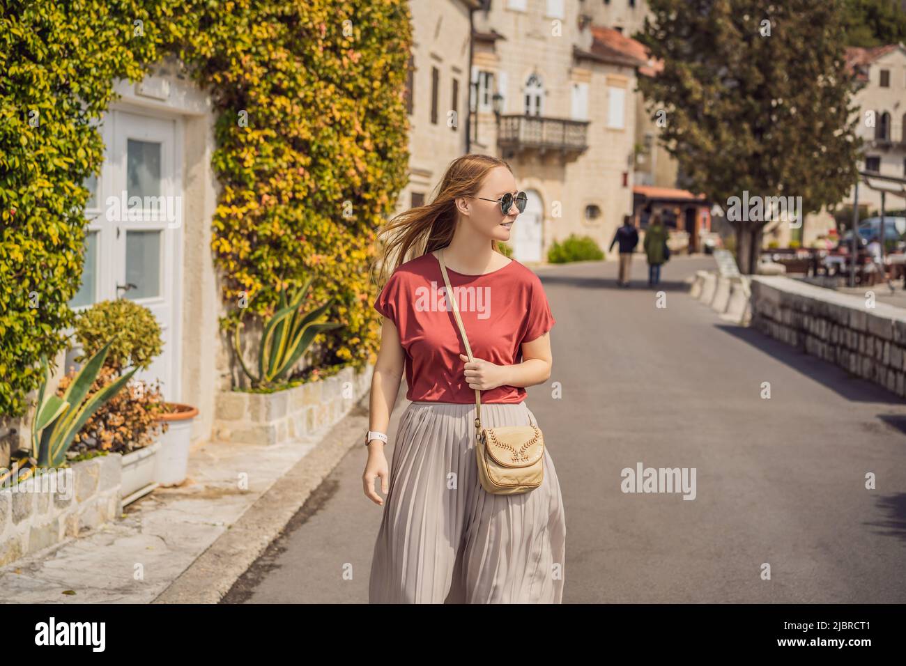 Woman tourist enjoying Colorful street in Old town of Perast on a sunny ...