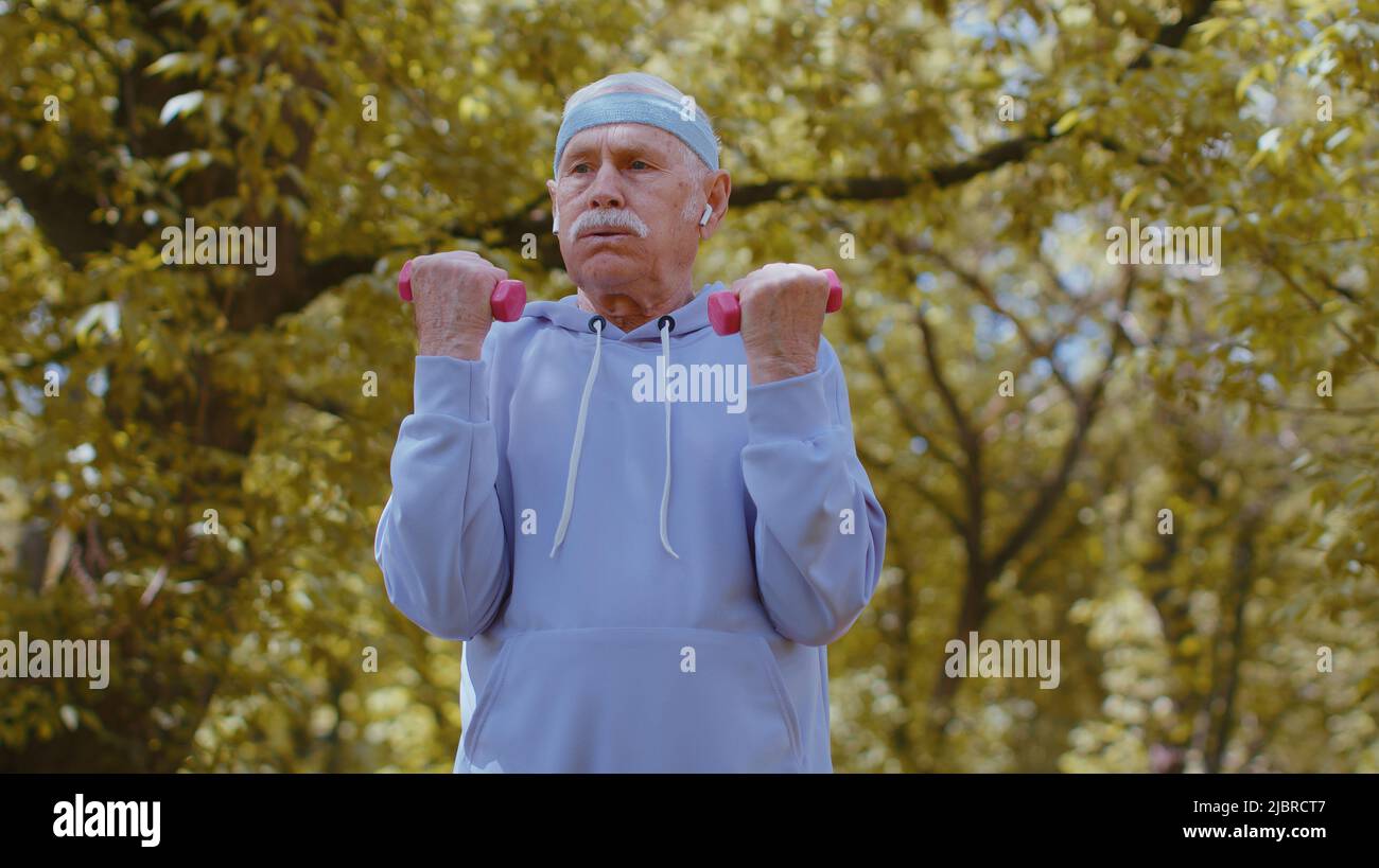 Fitness for seniors. Strong elderly old man exercising making dumbbell ...