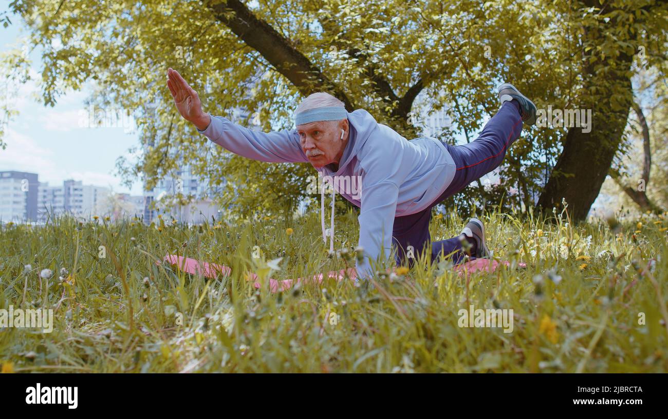 Fitness for seniors. Elderly man exercising at park making yoga ...