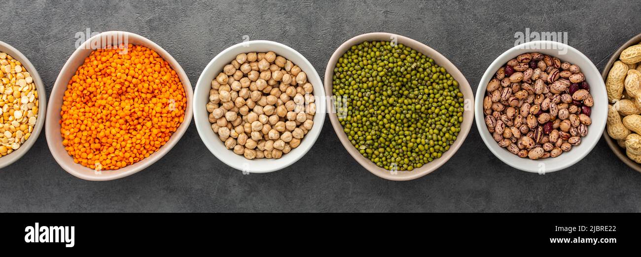 Banner of different types of legumes in bowls, yellow peas and ...