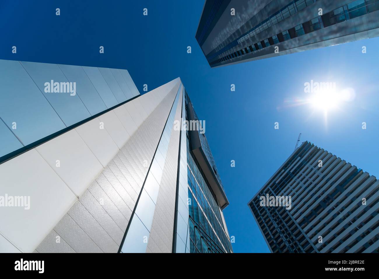 Modern glass buildings in the city on a sunny clear day with a blue sky ...