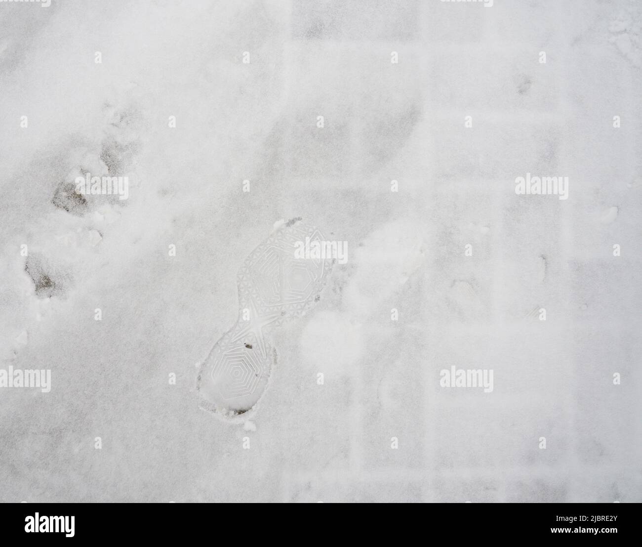 Snowy street tiles texture. Stone masonry on the pavement. Footprint in ...