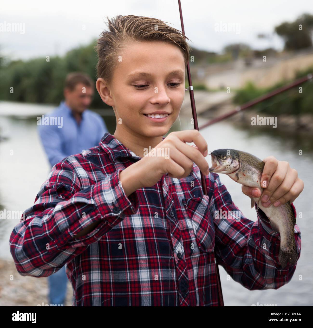 teenager boy holding catch fish on hook Stock Photo - Alamy