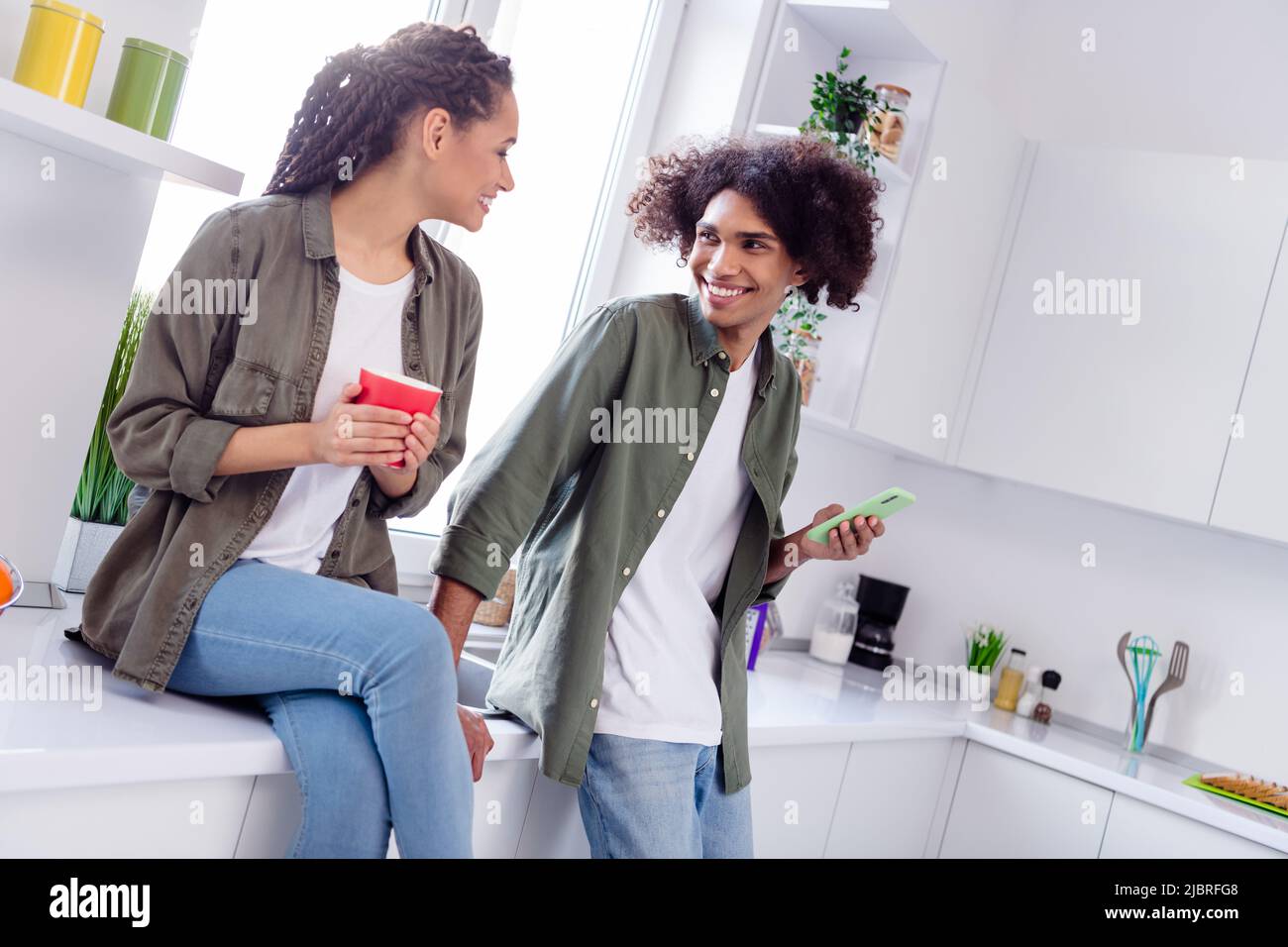 Photo of good mood siblings spend time together in kitchen enjoy ...