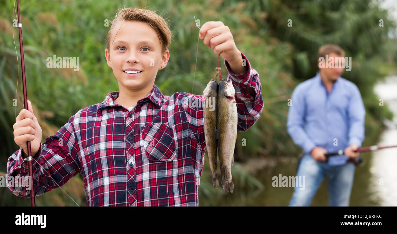 Positive teenage boy releasing catch on hook fish Stock Photo - Alamy
