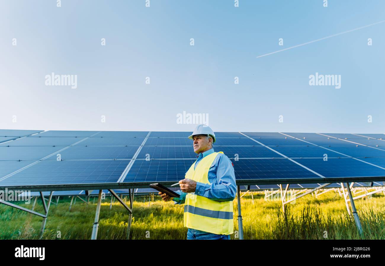 Solar engineer checking photovoltaic panels. Solar farm. Cover photo ...
