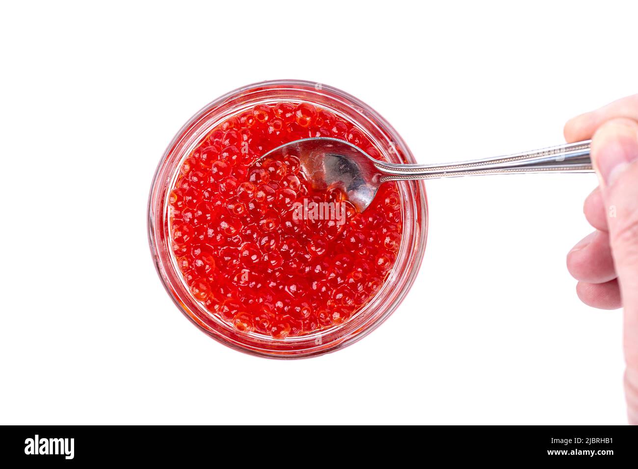 Scooping red caviar with a metal spoon. Top view, human hand blurred ...