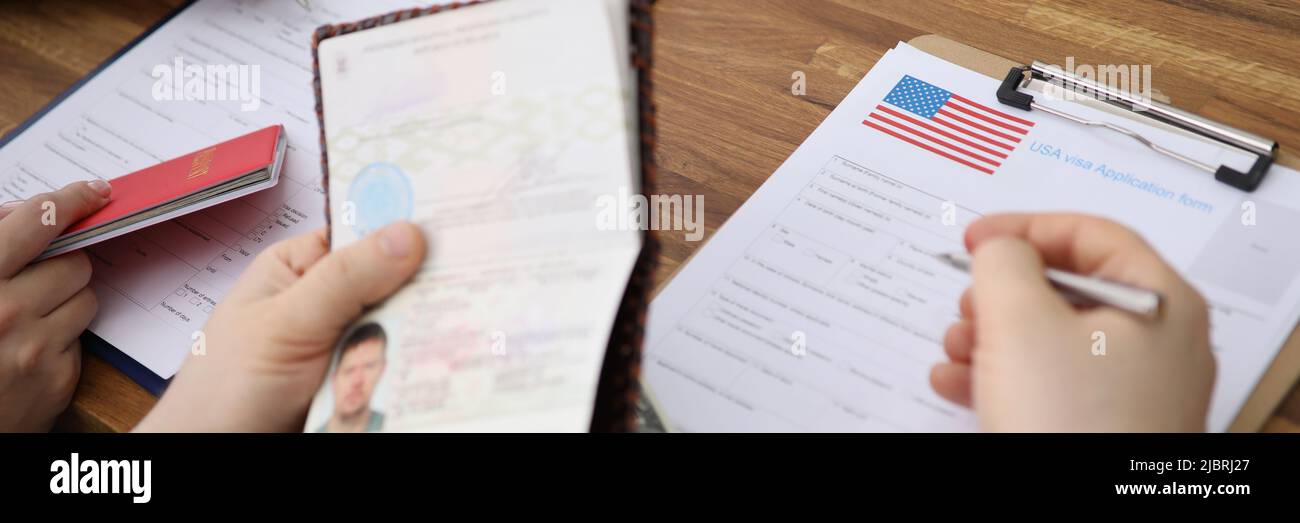People filling visa application forms with personal passports at ...