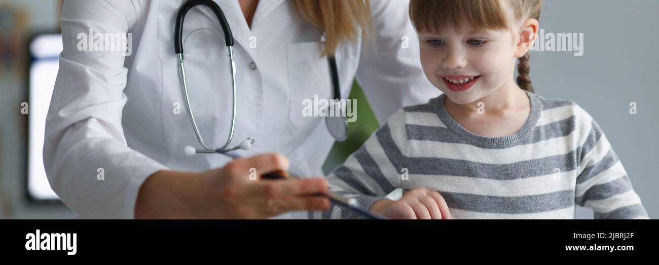 Pediatrician female try to distract child attention and make diagnostic ...