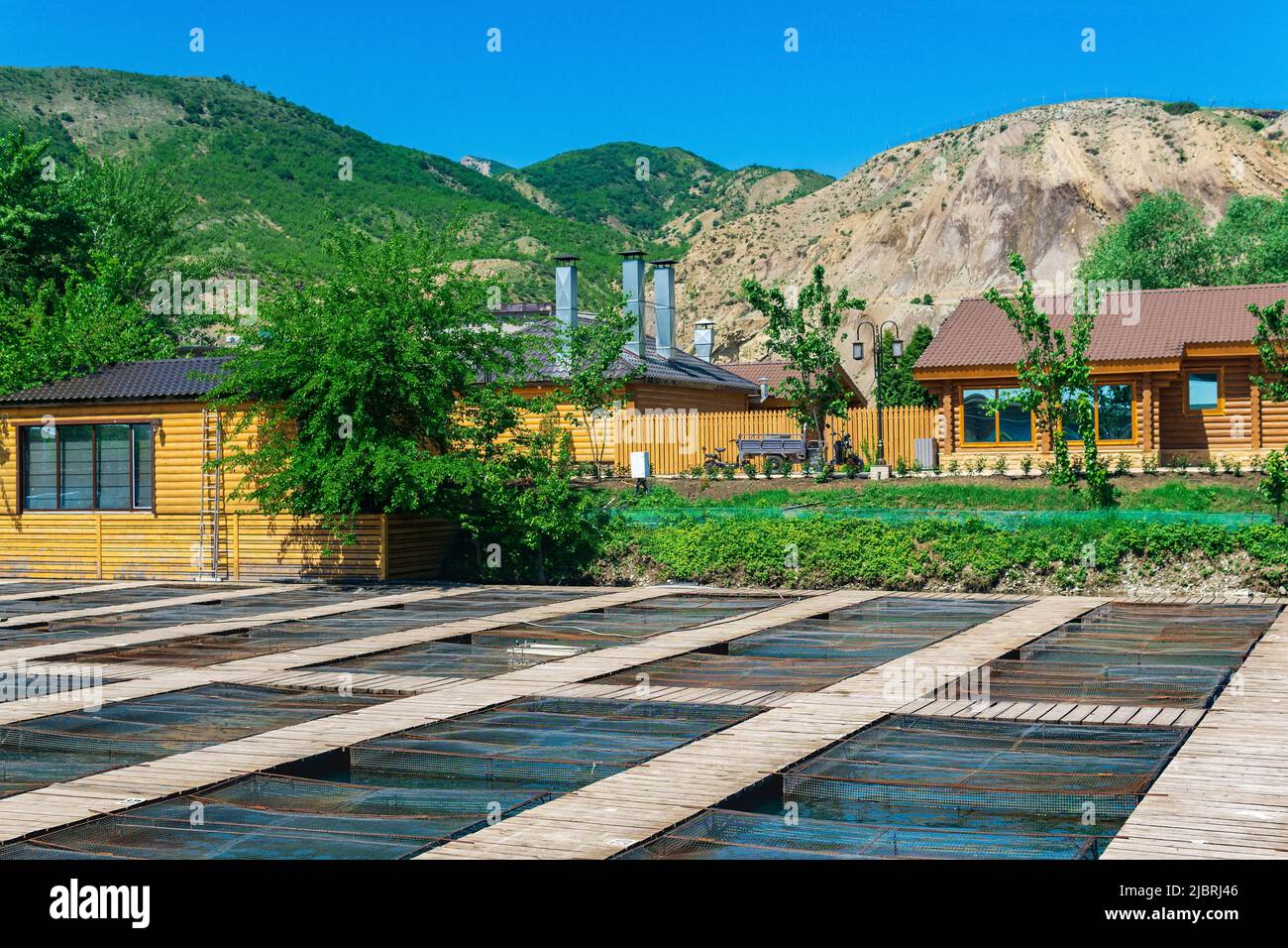 fish farm in a mountain valley with aquaculture cages and wooden ...