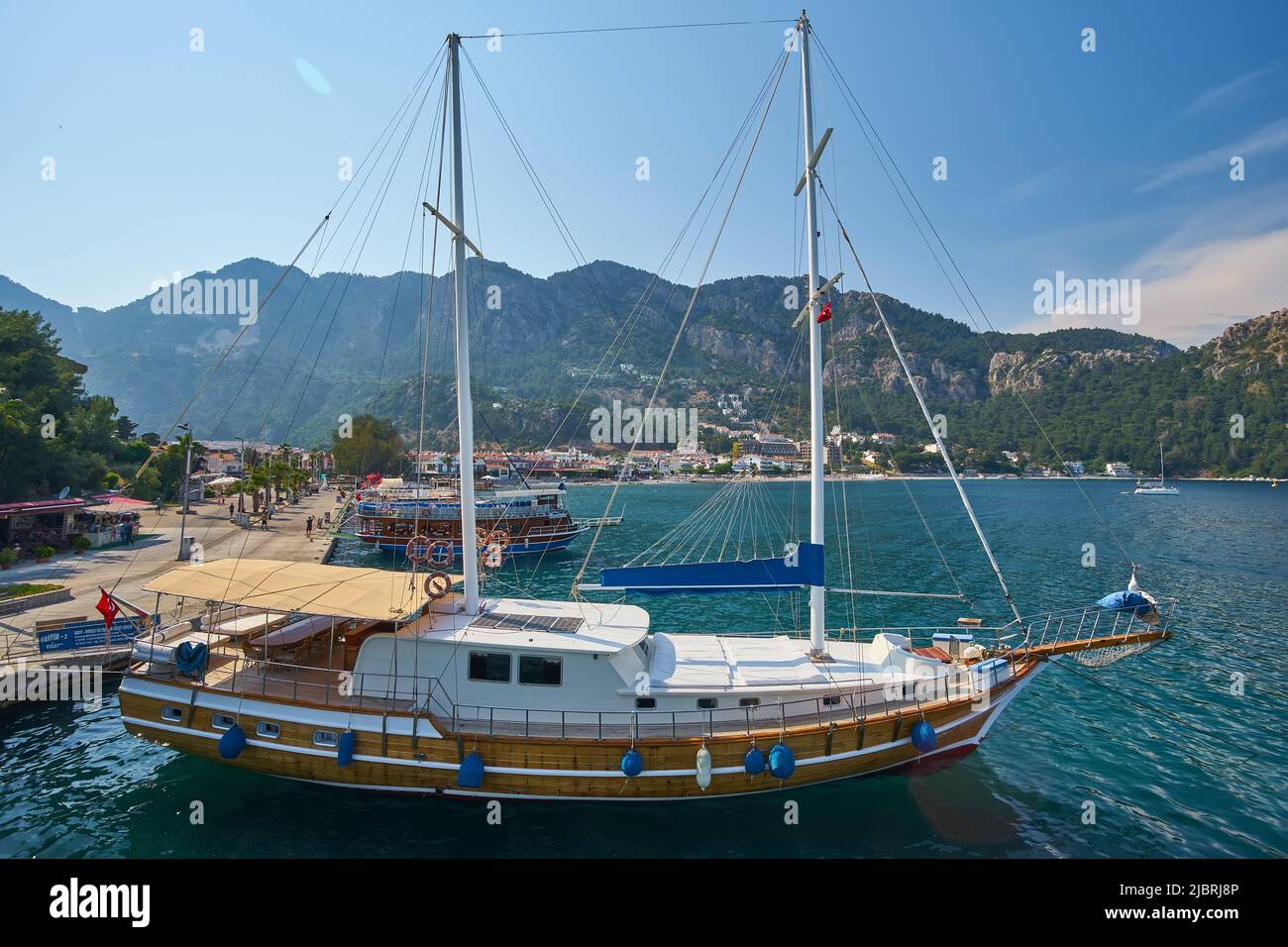 small boats moored in Aegean sea blue lagoon with mountainous islands ...