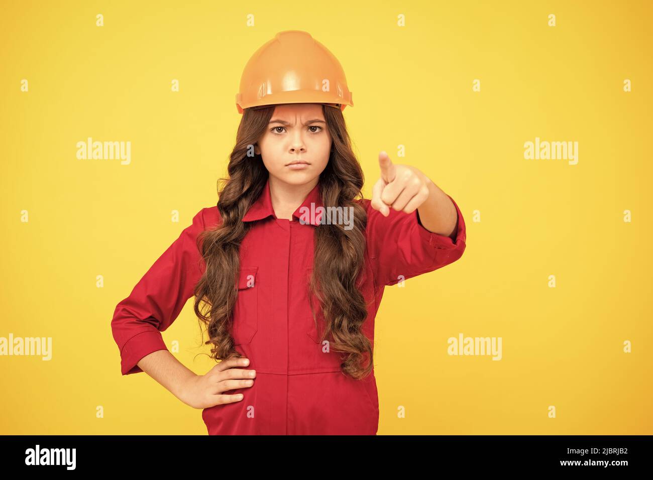 teen girl pointing finger. child in protective helmet for building ...