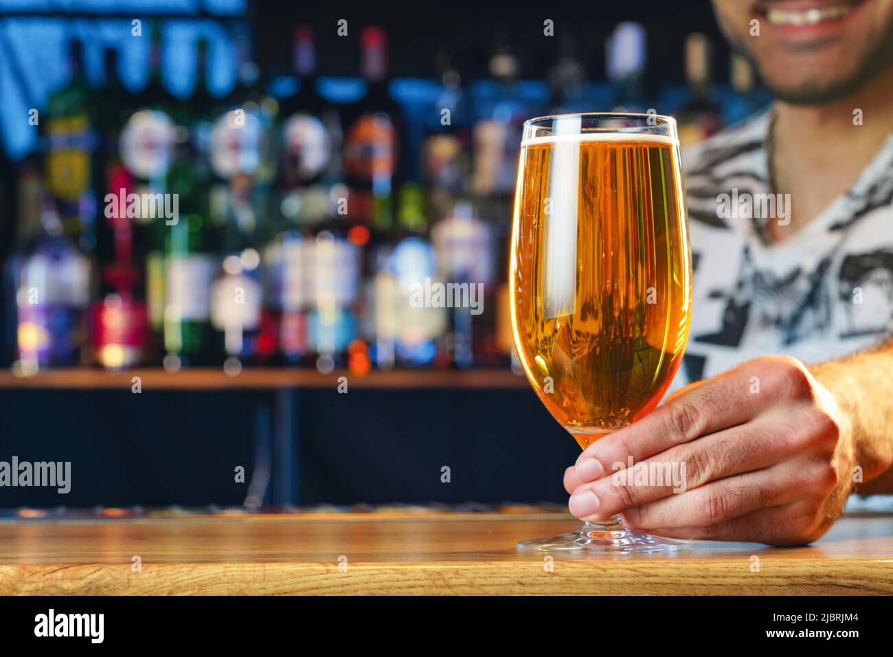 Barman serves glass of cold beer at bar counter in pub Stock Photo - Alamy