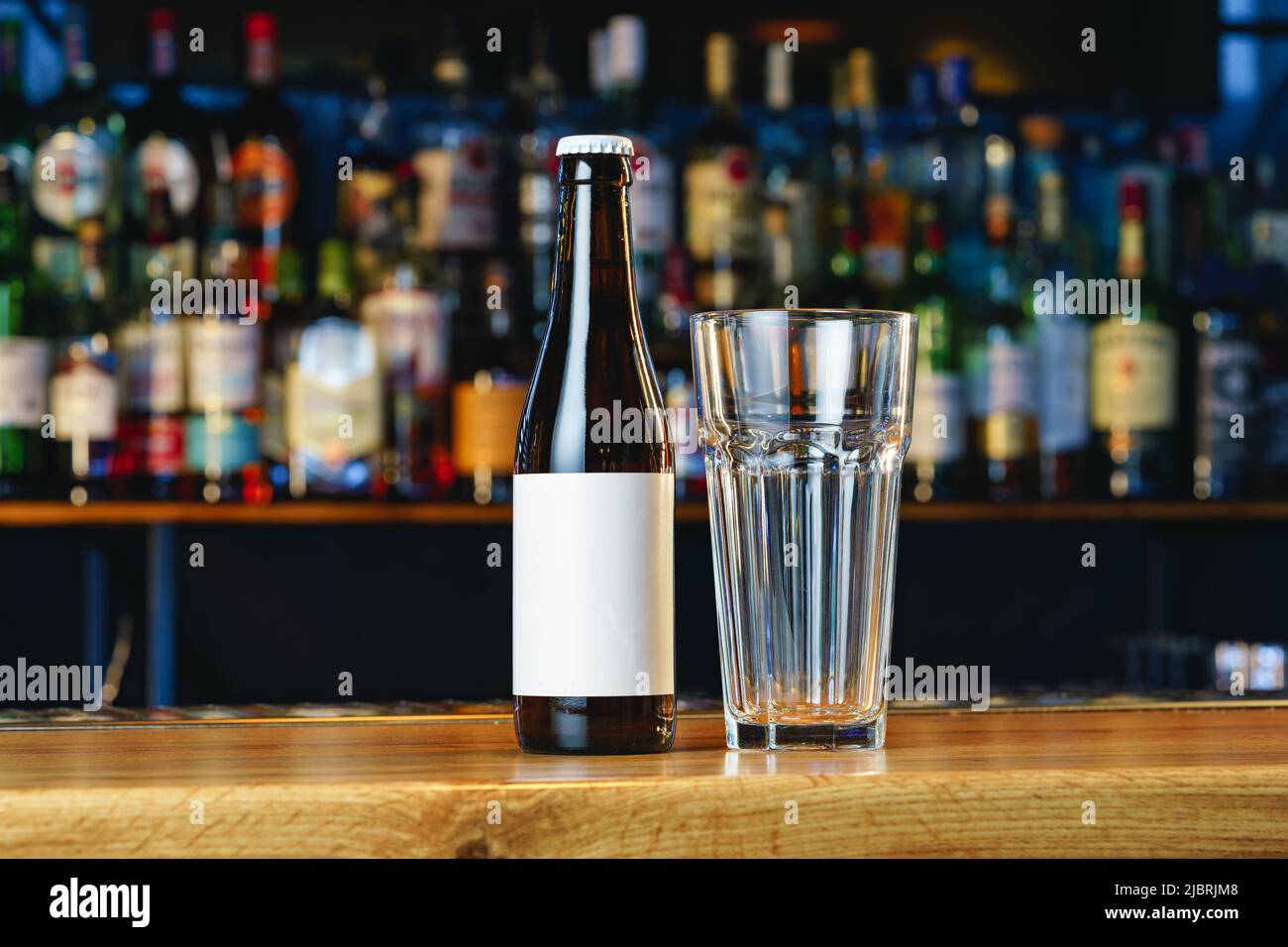 Beer glass and bottle on wooden countertop in a pub Stock Photo - Alamy