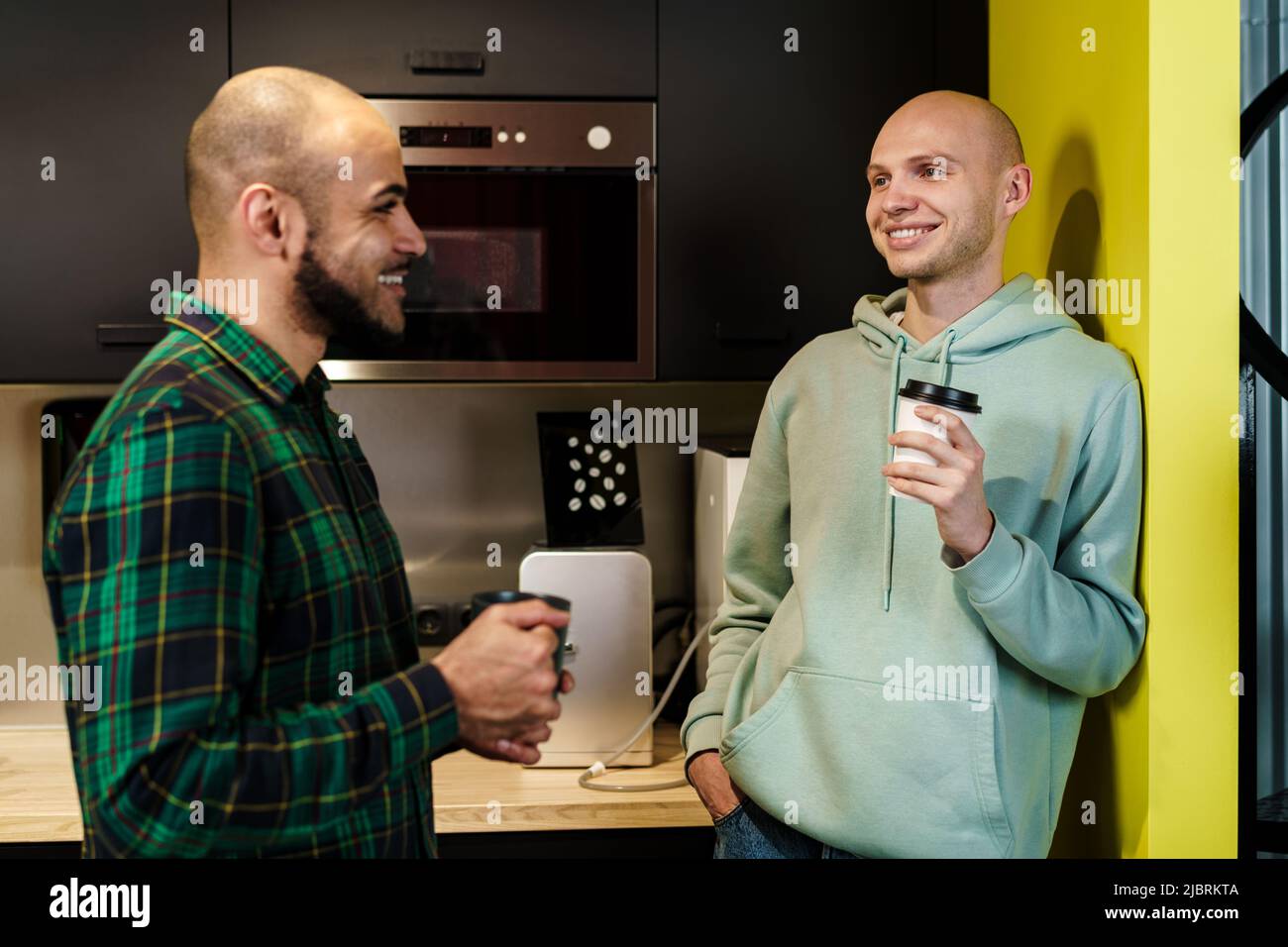 Two male colleagues having a talk while coffee break in office Stock ...