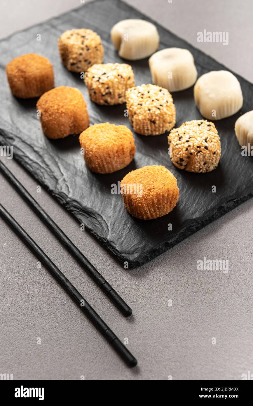 Many different delicious mochi on grey table, flat lay. Traditional ...