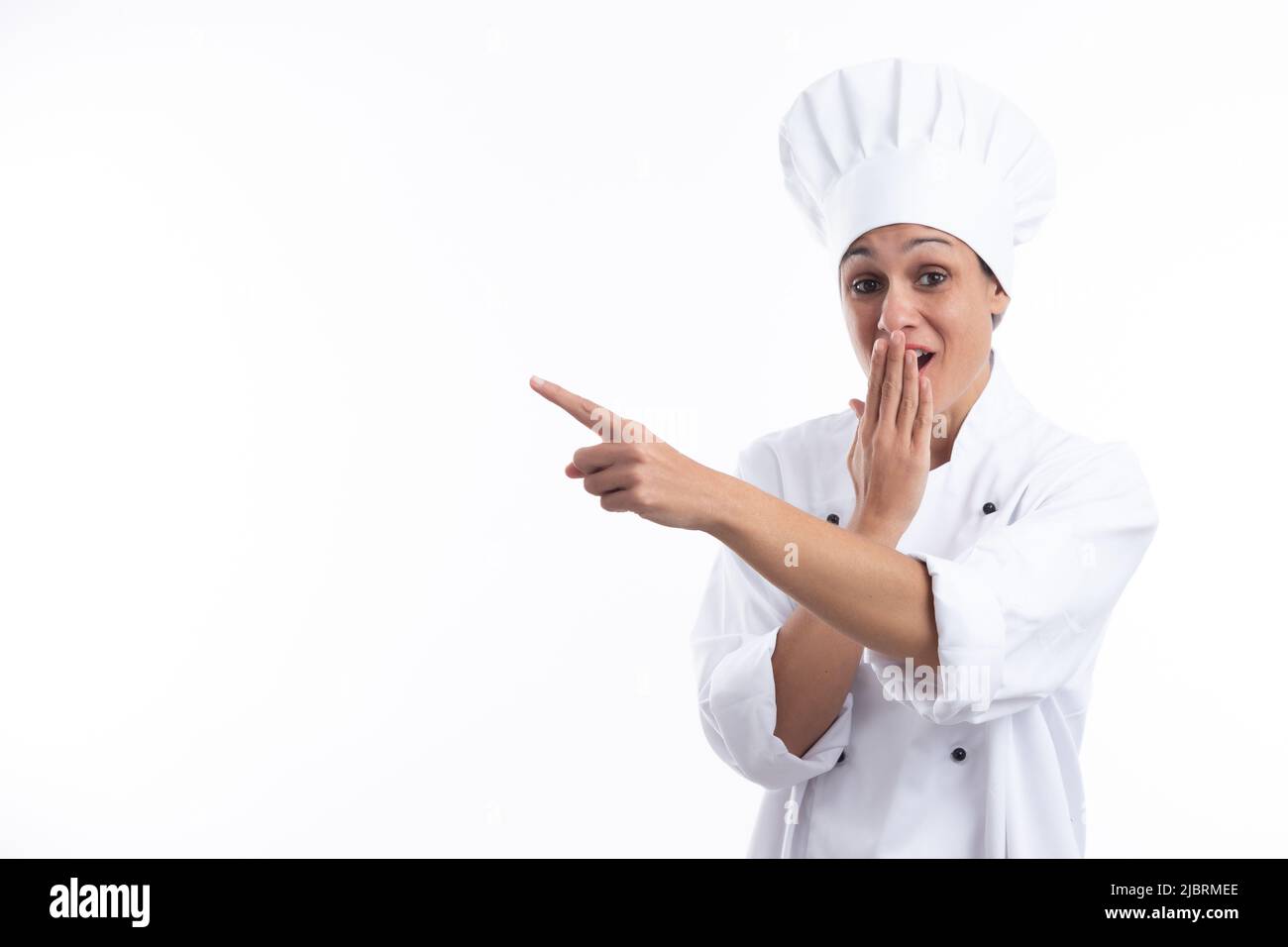 Woman chef looking at camera in surprise, pointing with finger isolated ...
