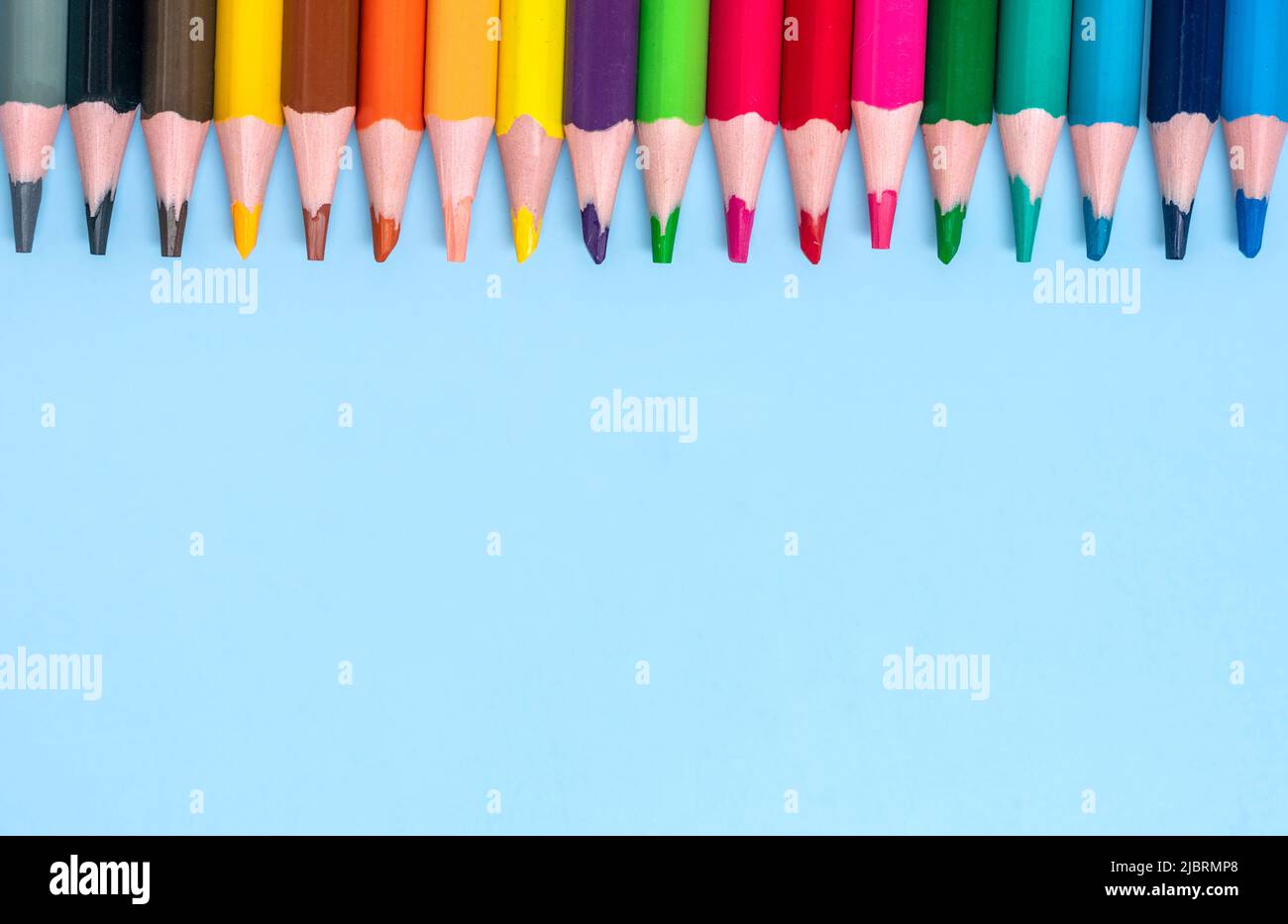 set of colored pencils isolated on blue background Top view Flat lay ...