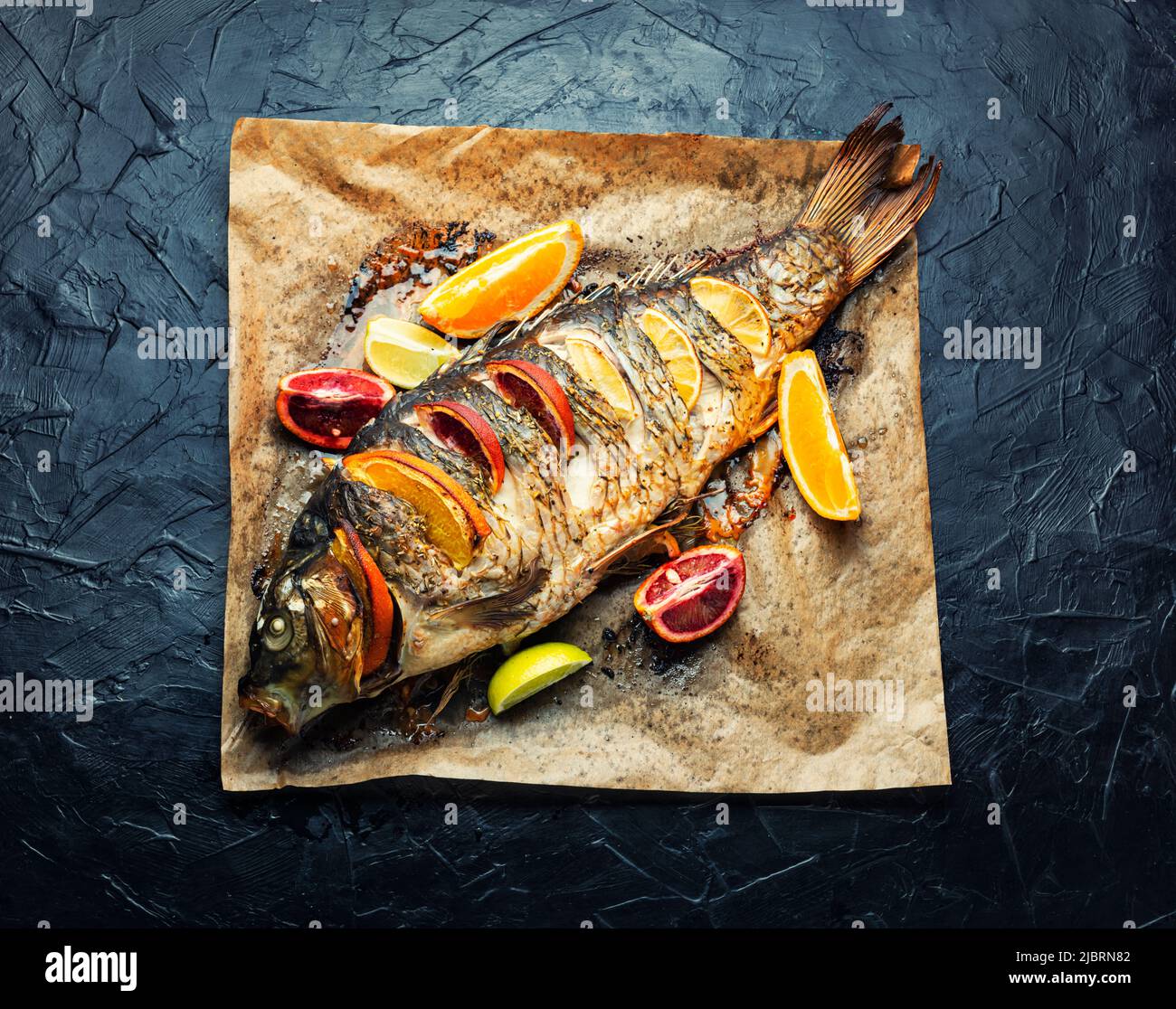 River fish carp grilled whole with lemon and oranges Stock Photo - Alamy