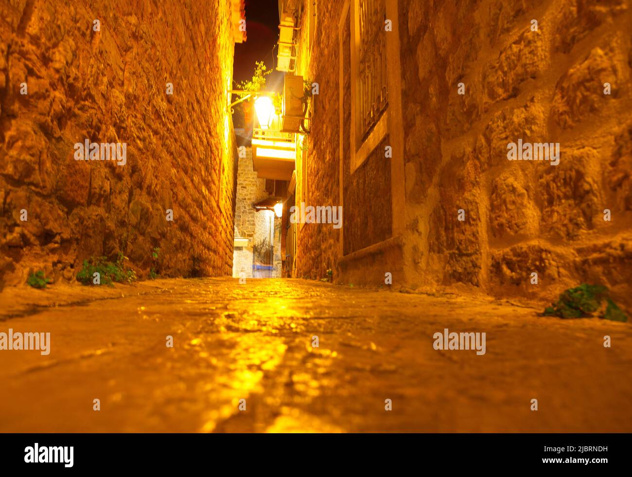 Illuminated narrow street in old town . Medieval street light and ...