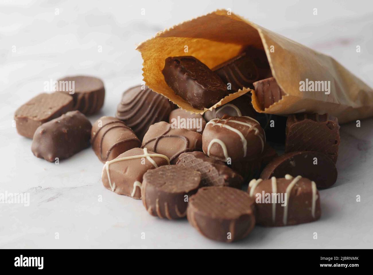 dark chocolate spilling from a paper packet Stock Photo - Alamy