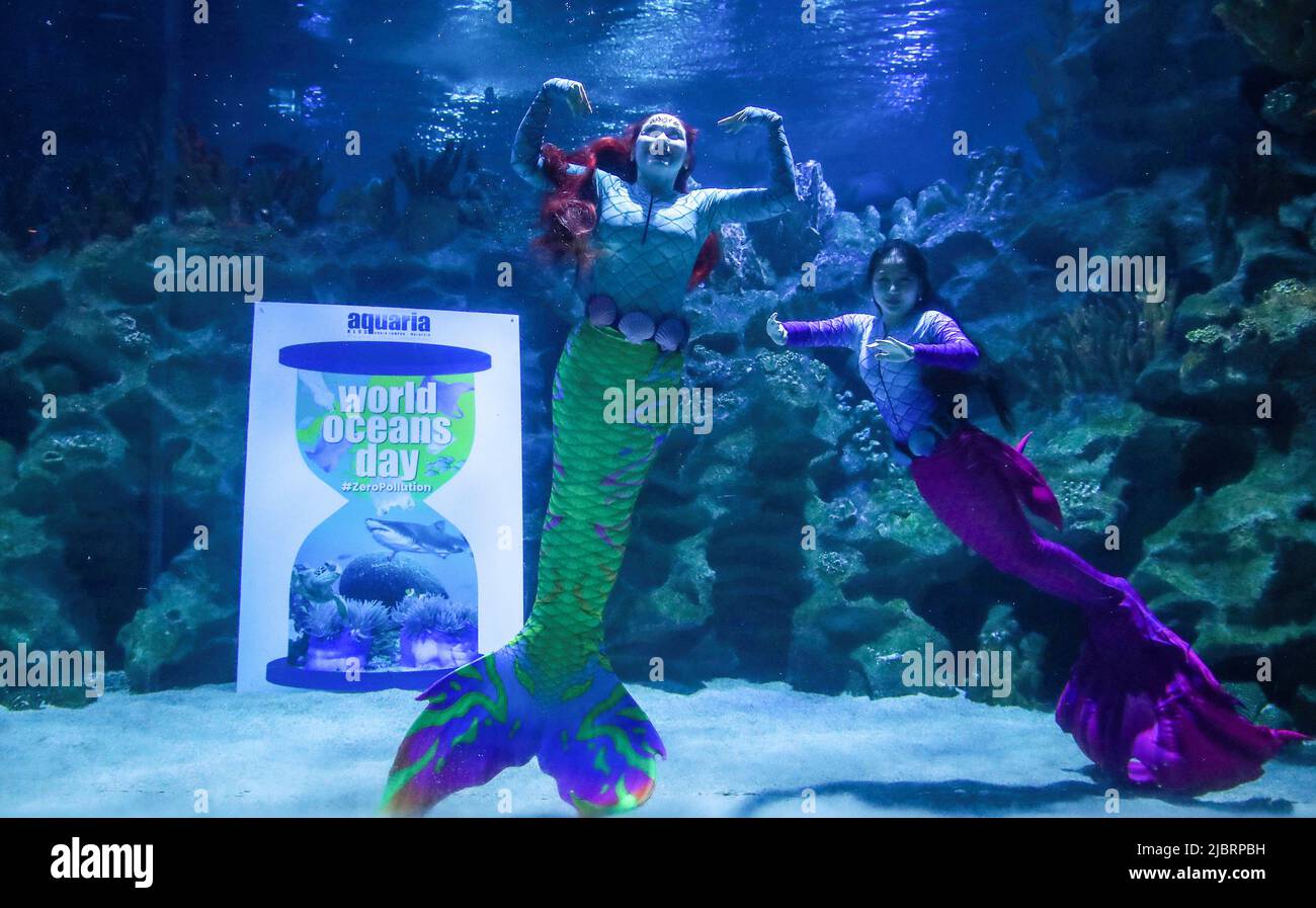 Divers dressed as mermaids perform in the main aquarium of Aquaria KLCC ...