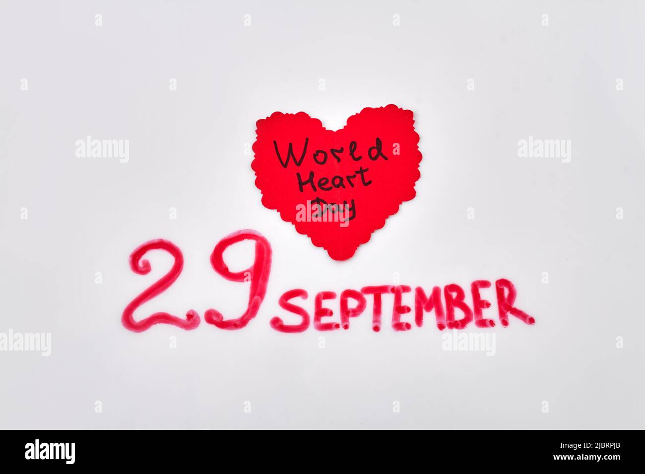 29 september world hearts day written on red heart. Isolated on white ...
