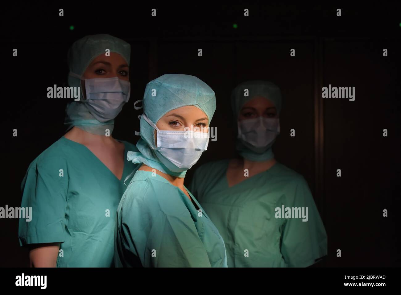 Three nurses are seen in a surgical operation theater. They are dressed ...