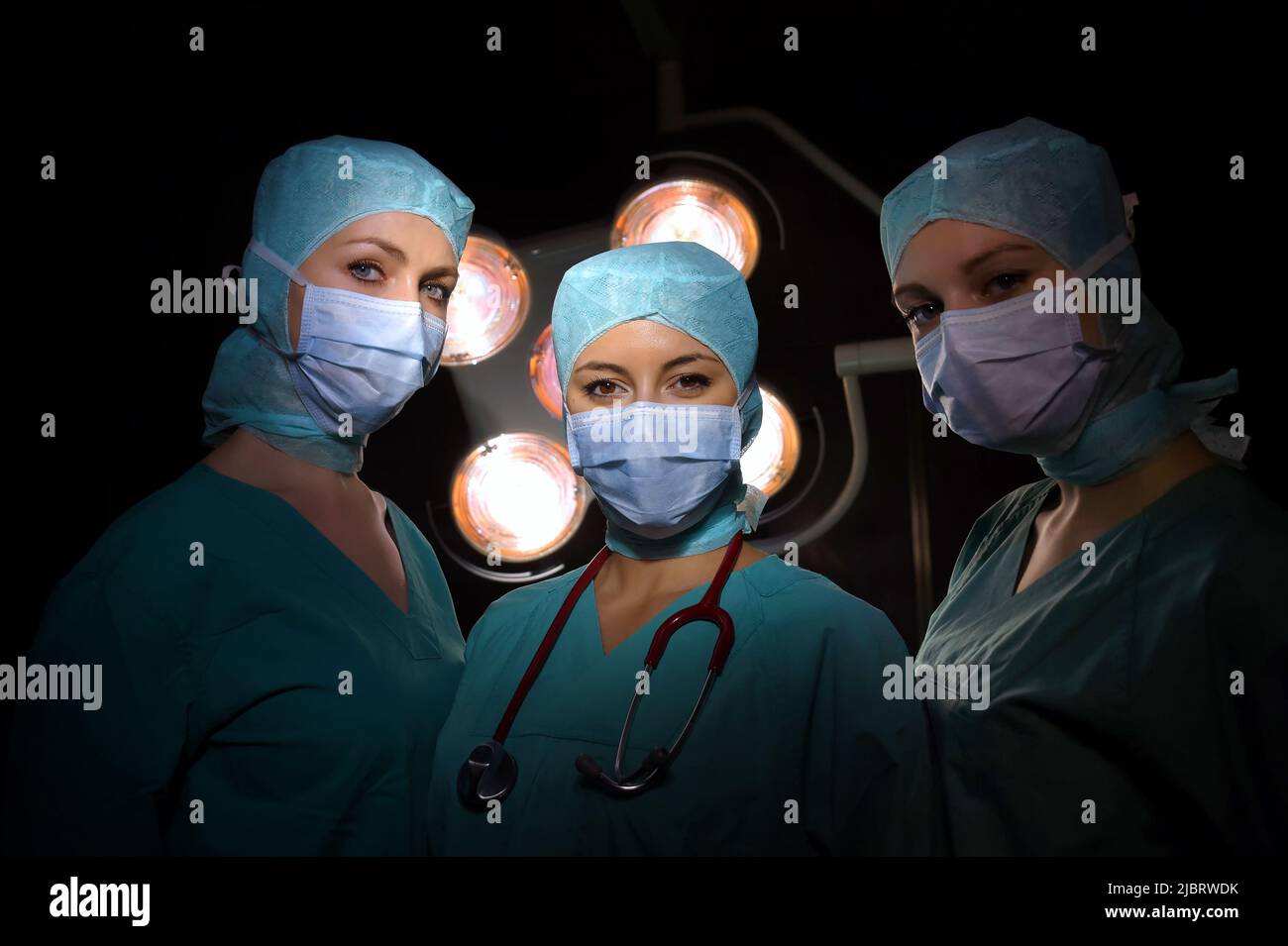 Three nurses are seen in a surgical operation theater. They are dressed ...