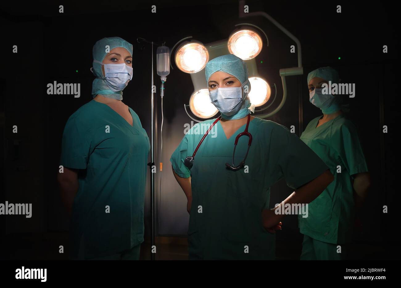 Three nurses are seen in a surgical operation theater. They are dressed ...