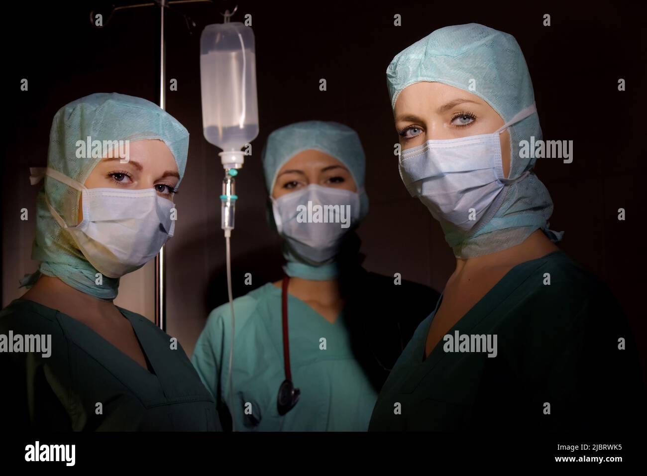 Three nurses are seen in a surgical operation theater. They are dressed ...