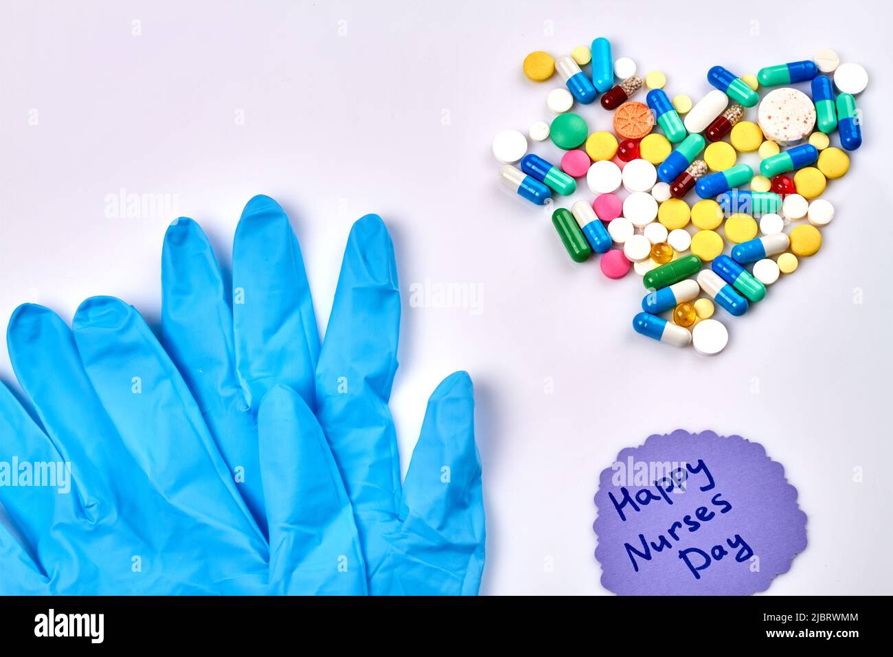 Top view flat lay colored tablet pills and blue rubber gloves. Happy ...