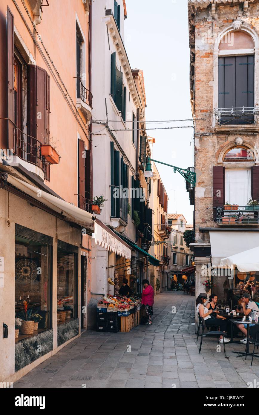 Venice, Italy - May 21, 2022: View of shops and restaurants on a narrow ...