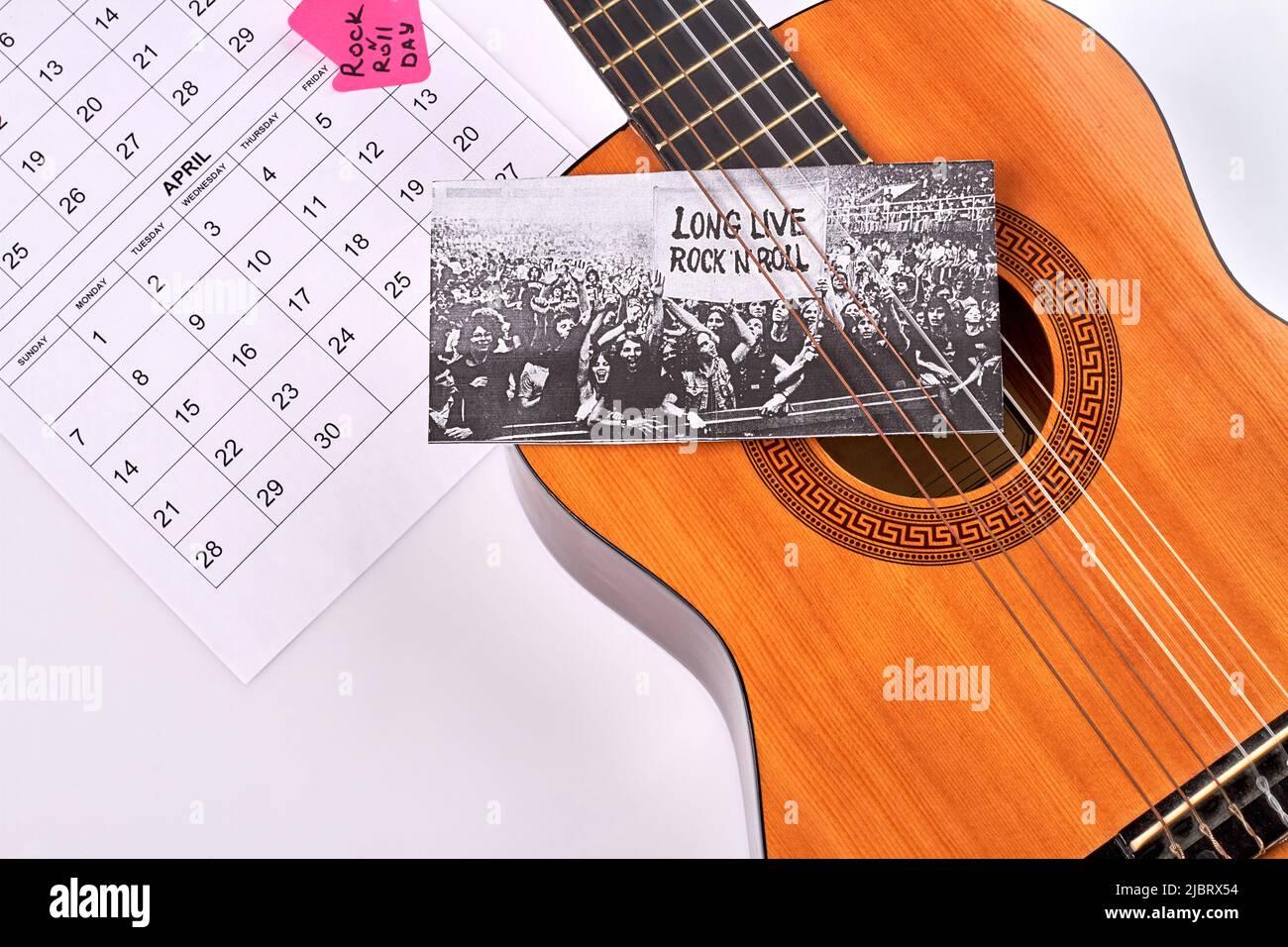 Concept of rock n roll day marked in the calendar. Retro wooden guitar ...