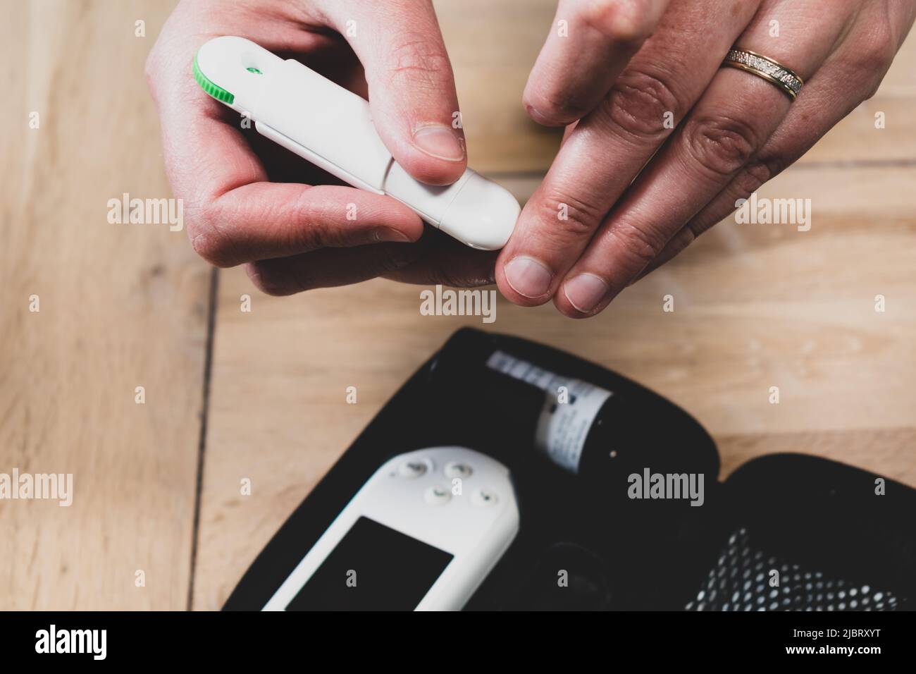Woman pricking her finger to check blood glucose level with glucometer ...