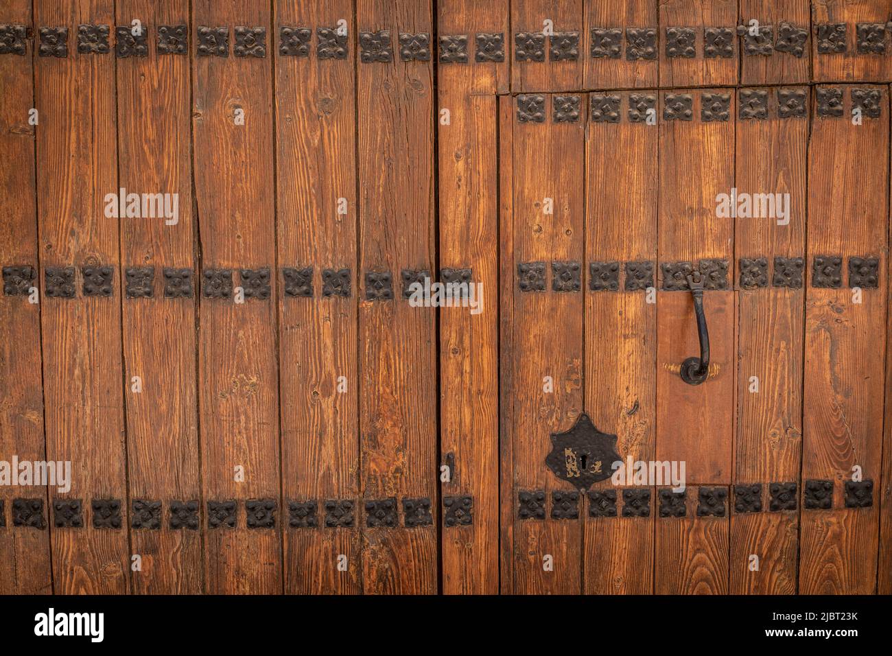 Double door in solid varnished and aged wood with antique metal ...