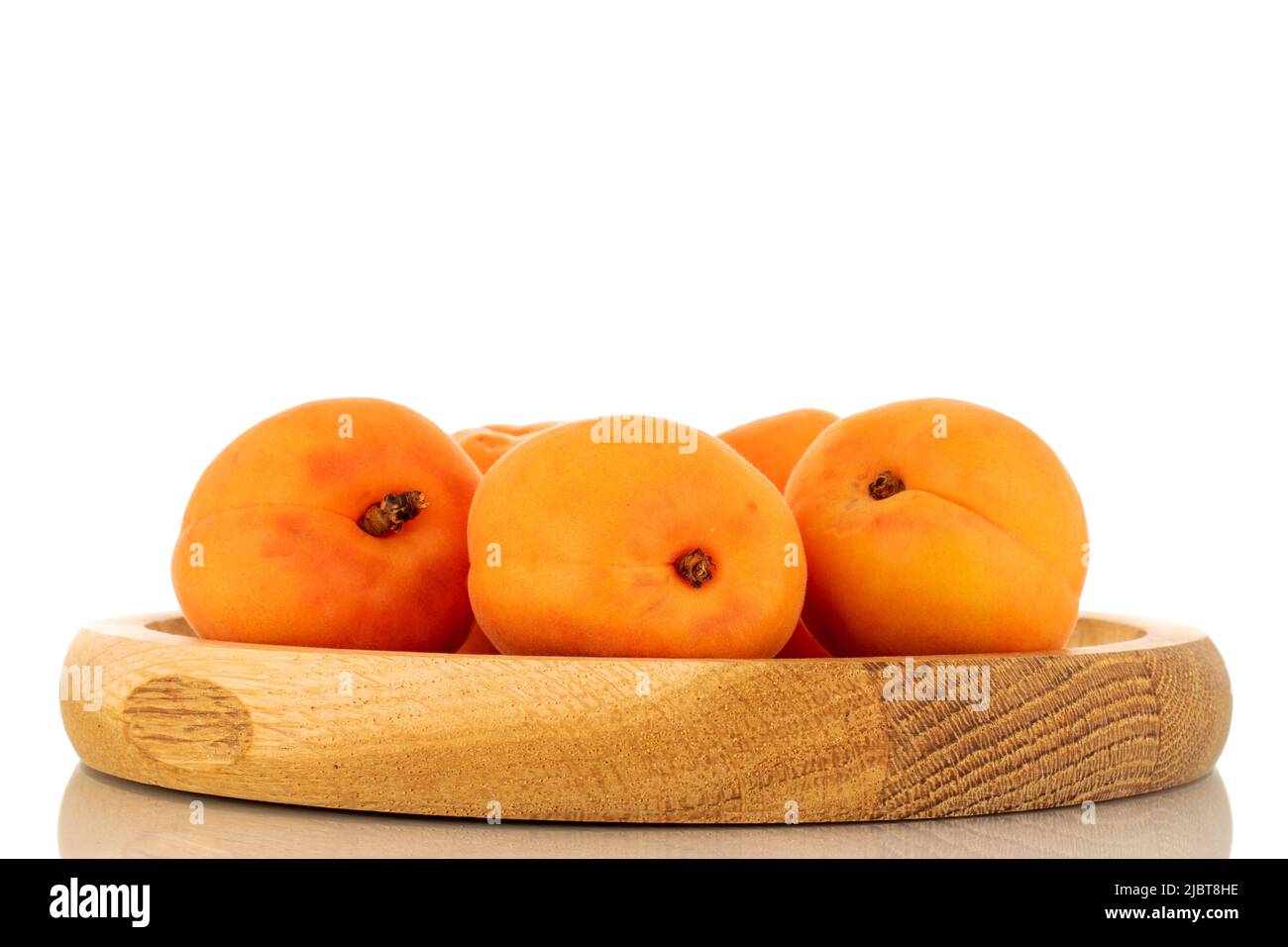 Several ripe sweet apricots with a wooden tray, close-up, isolated on a ...
