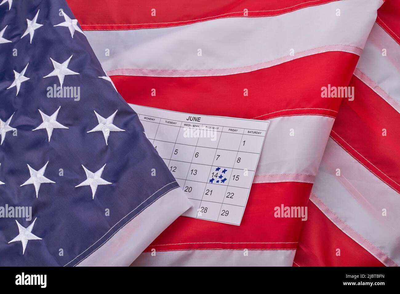 Close-up large fabric us flag and calendar with marked june 14th ...