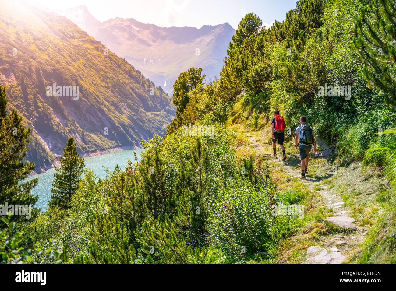 Alpine track and two hikers at mountain lake Stock Photo - Alamy