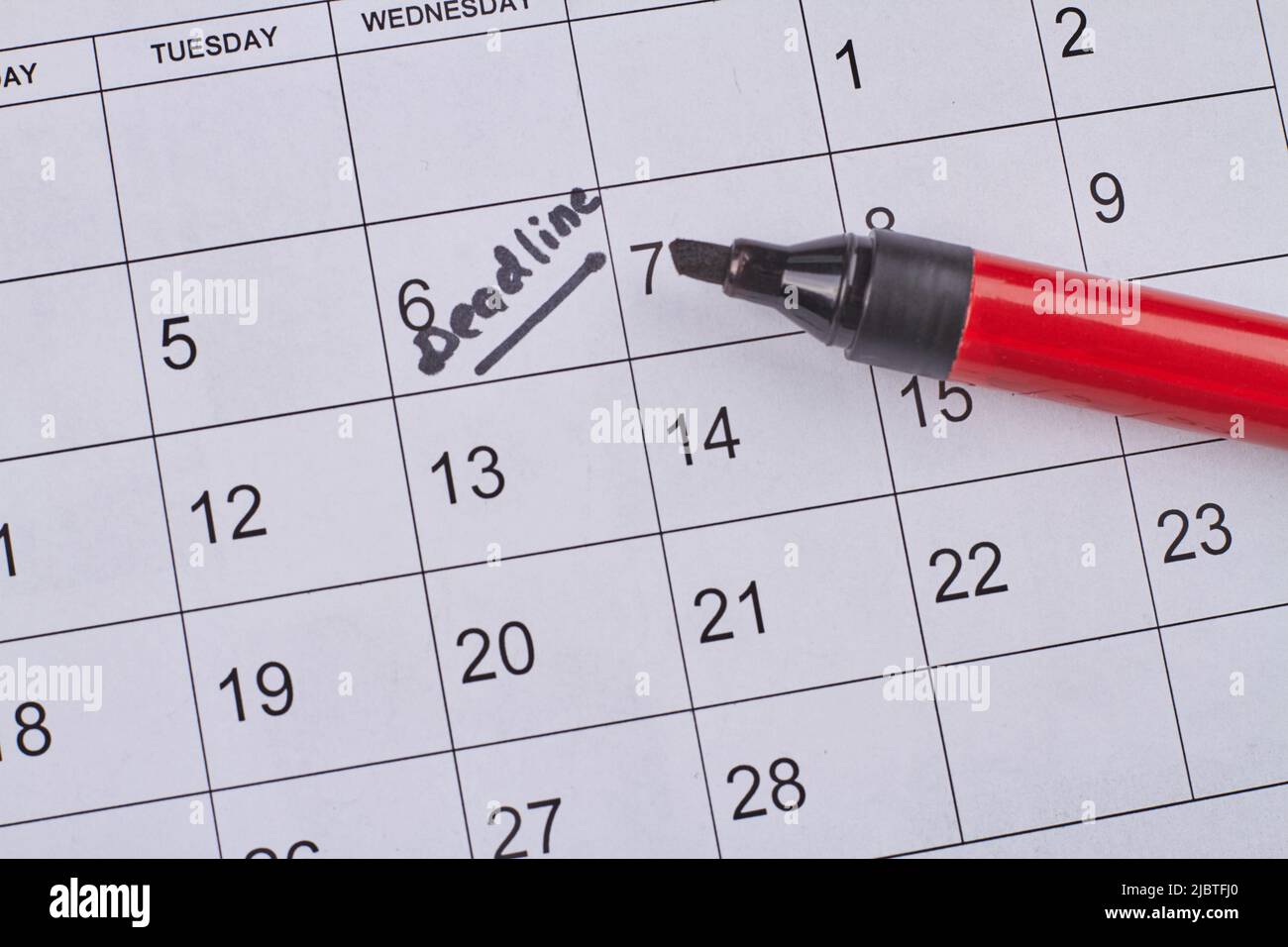 Deadline word written on the calendar by black marker top view. Black ...